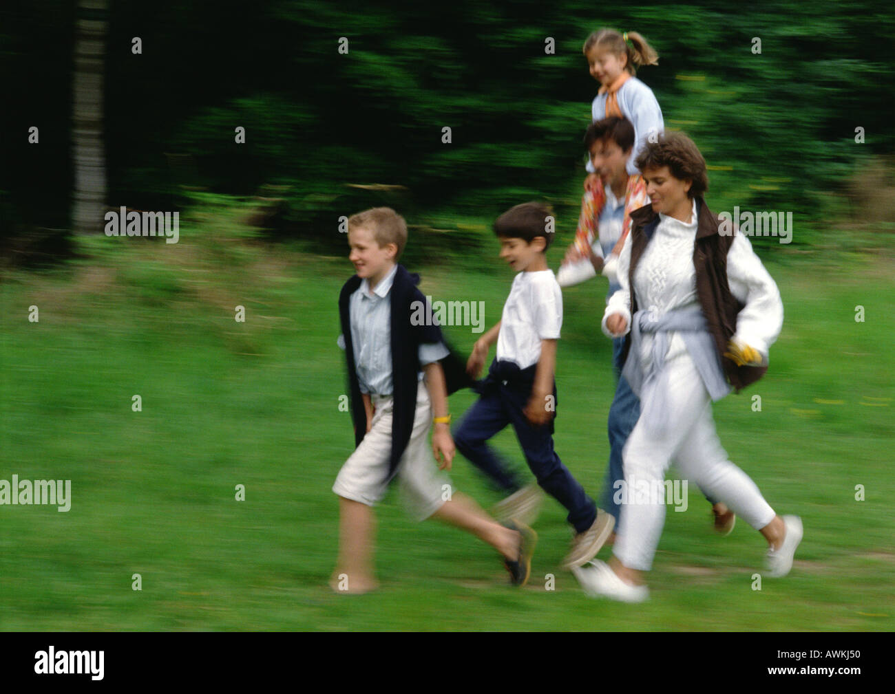 Family running together outside, blurred Stock Photo - Alamy