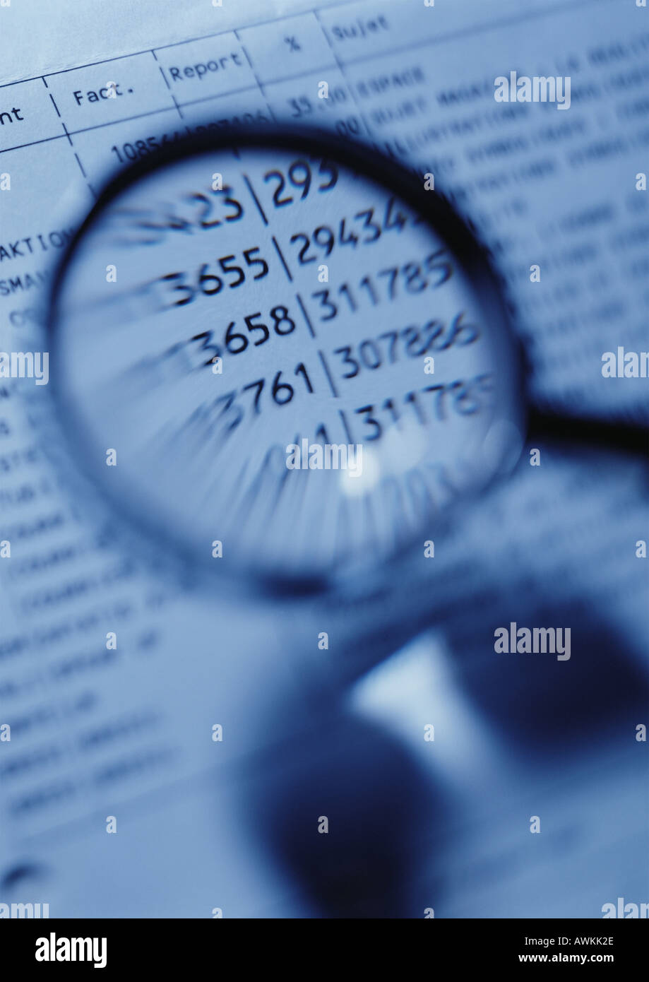 Magnifying glass magnifying numbers on document, close-up, blurred ...