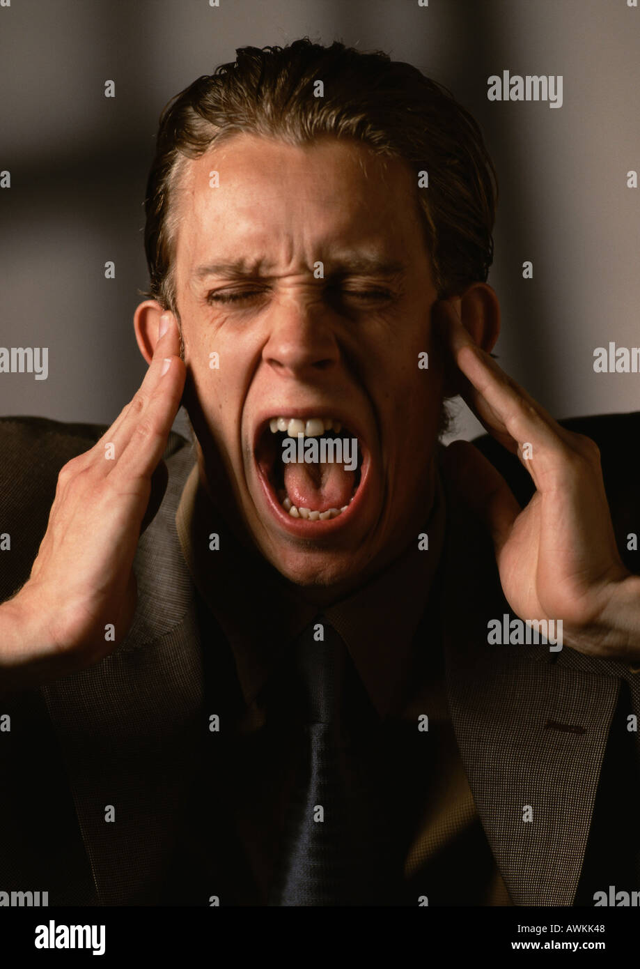 Man covering ears and screaming Stock Photo - Alamy