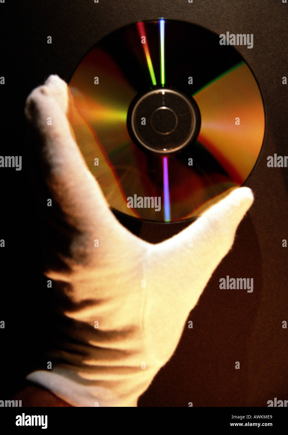 Gloved hand holding CD, close-up Stock Photo - Alamy