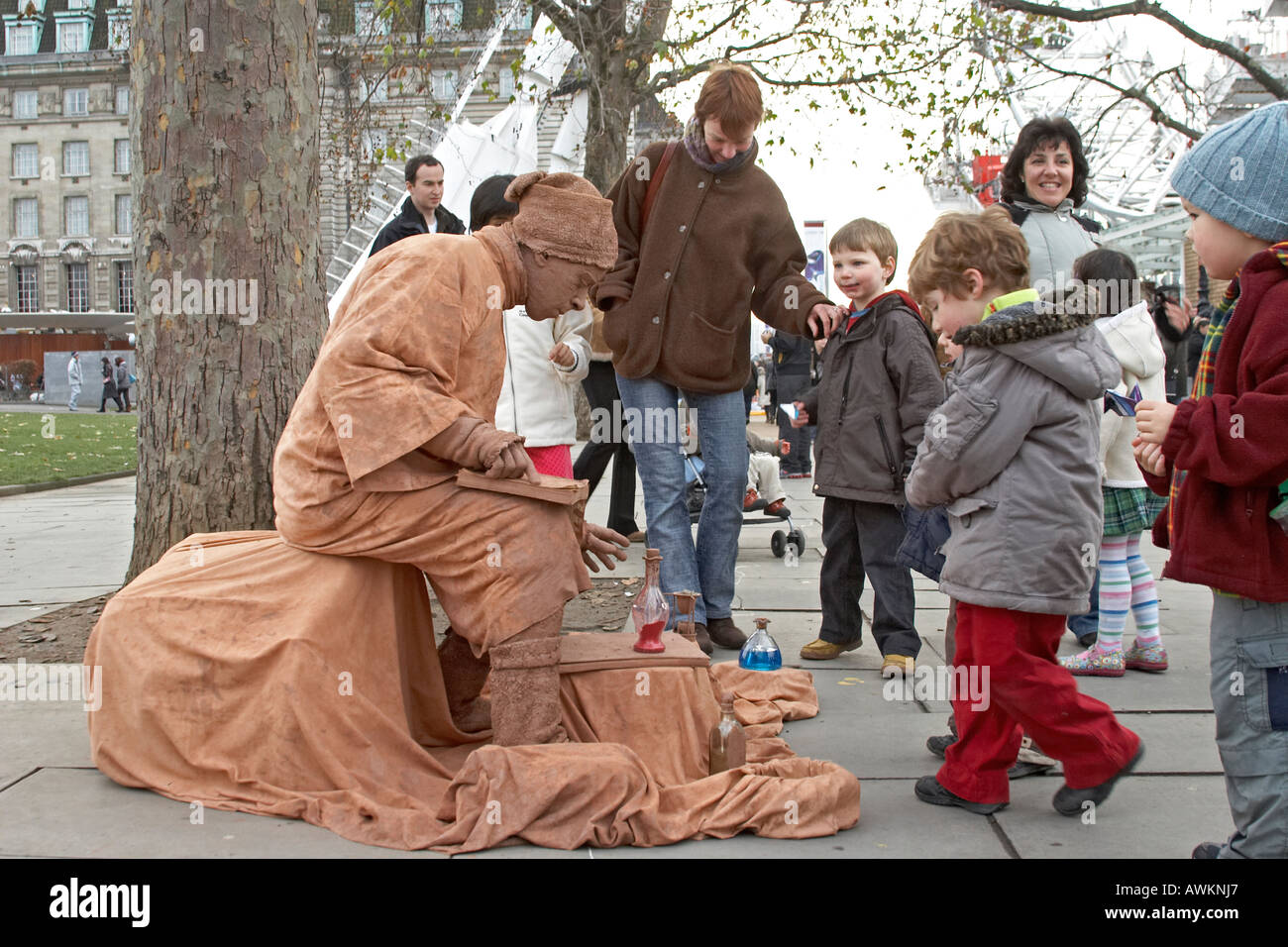 Children with human statue busker figure on South Bank on cloudy winter ...