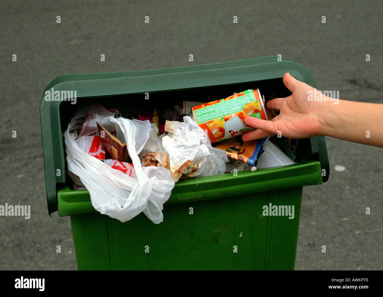 Person putting aluminum can into overflowing trash bin Stock Photo - Alamy