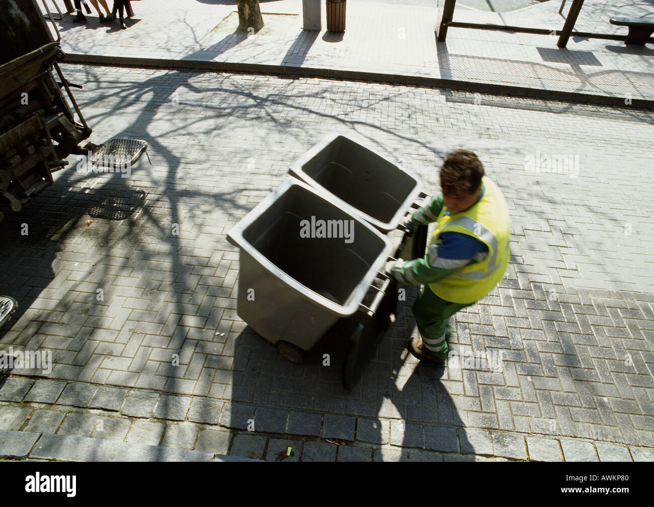 Trash collector pulling two trash cans away from dump truck Stock Photo ...