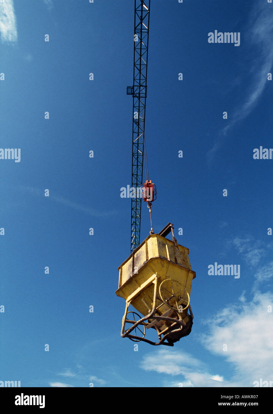 Crane lifting cement mixer, sky in background Stock Photo - Alamy