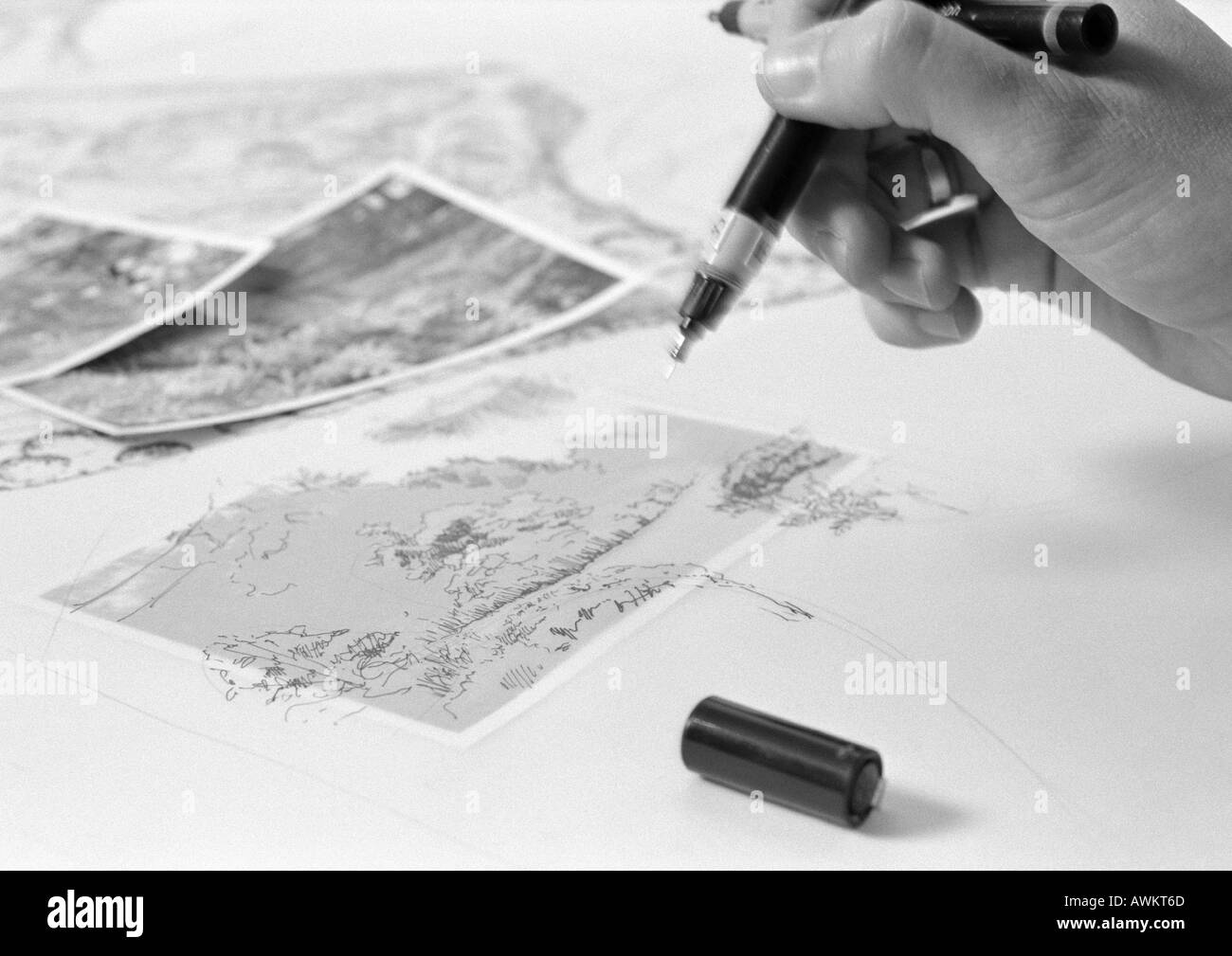 Hand holding pens above drawing, close-up, b&w Stock Photo - Alamy