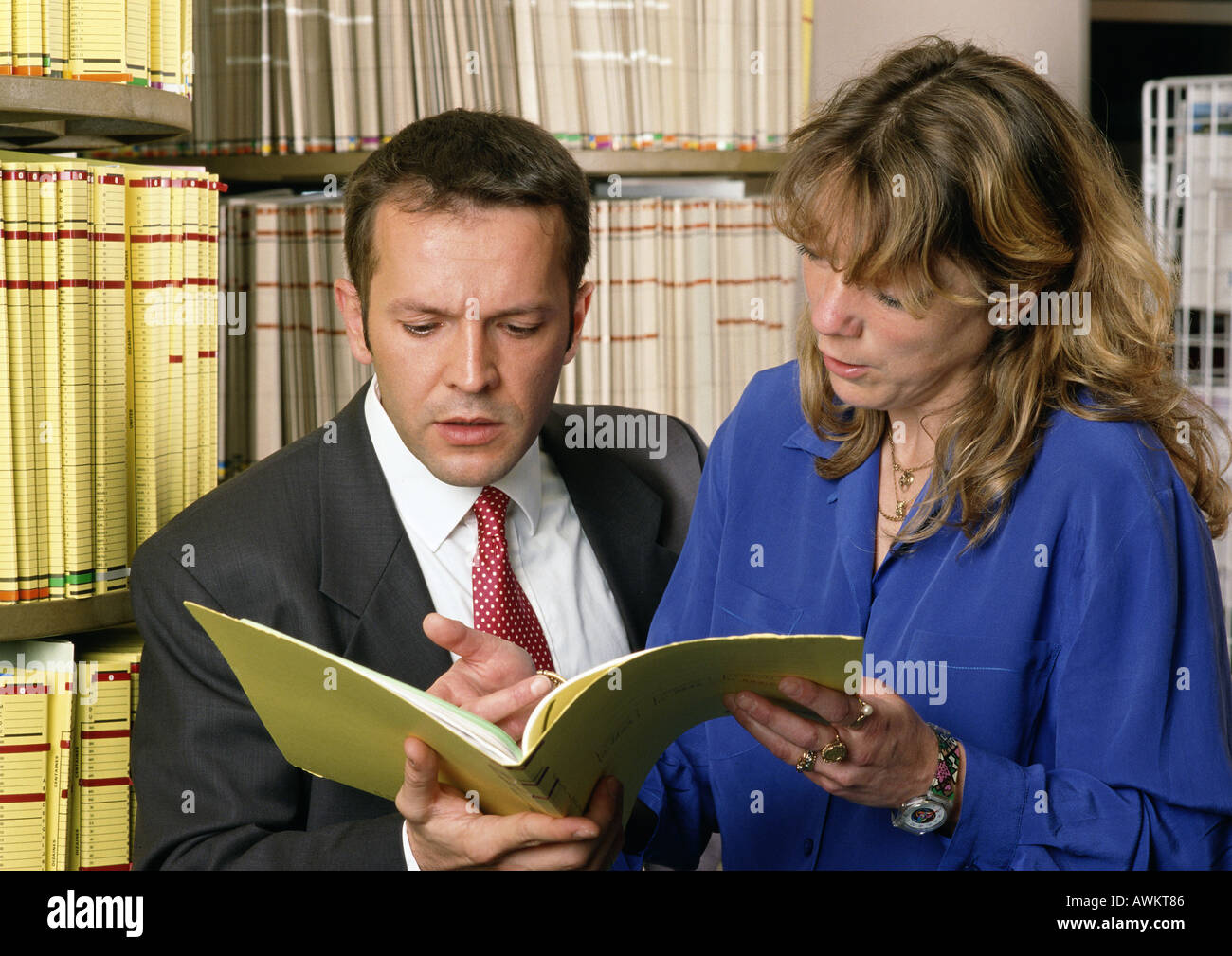 Man and woman examining document Stock Photo - Alamy