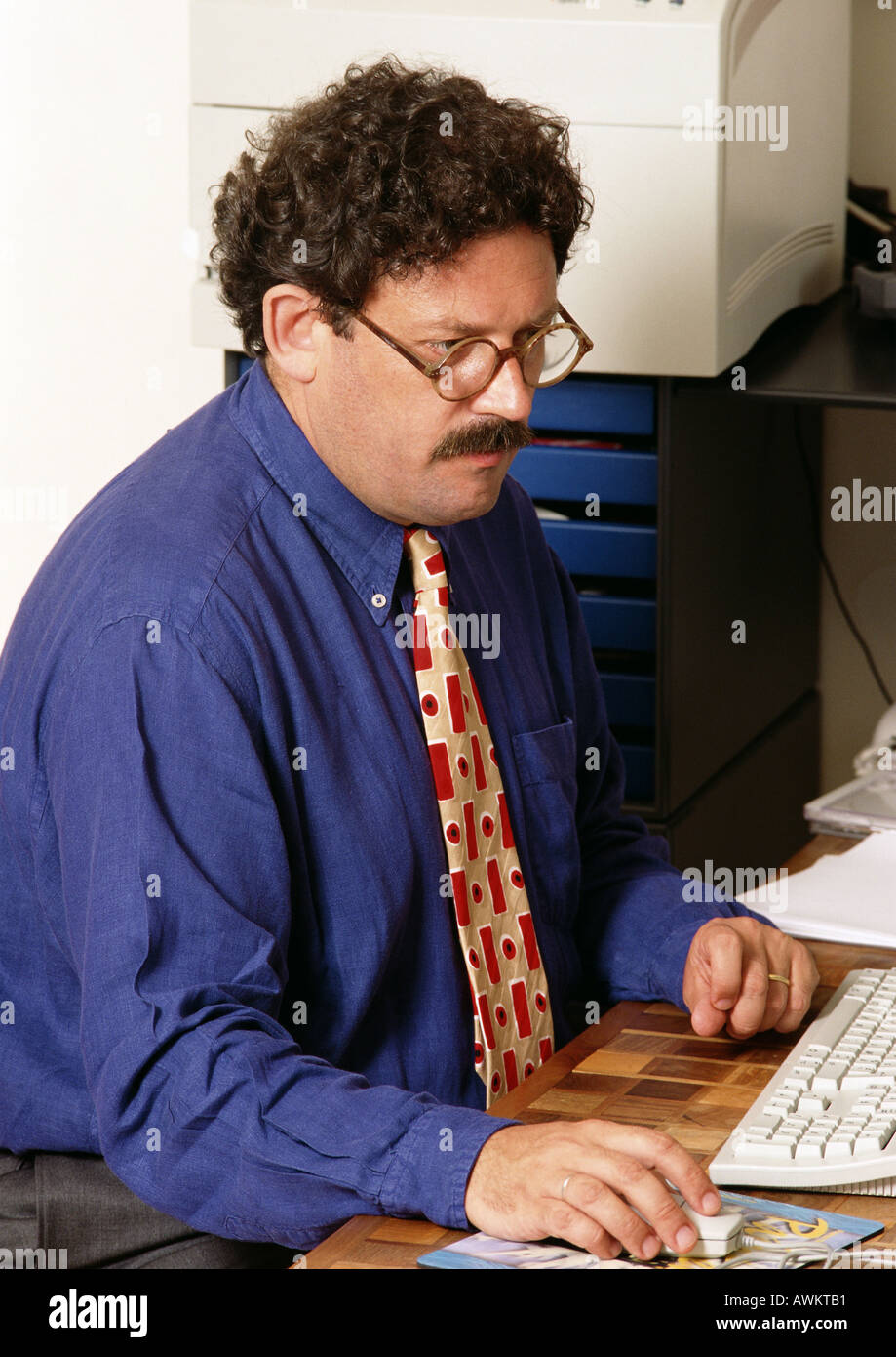 Man sitting at desk, holding mouse Stock Photo - Alamy