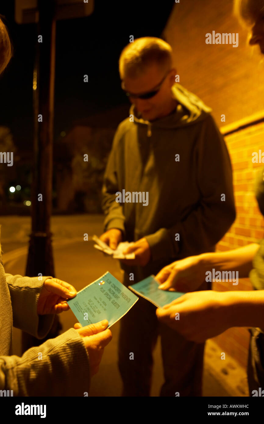 Ticket tout counts the cash after selling event tickets on a street ...