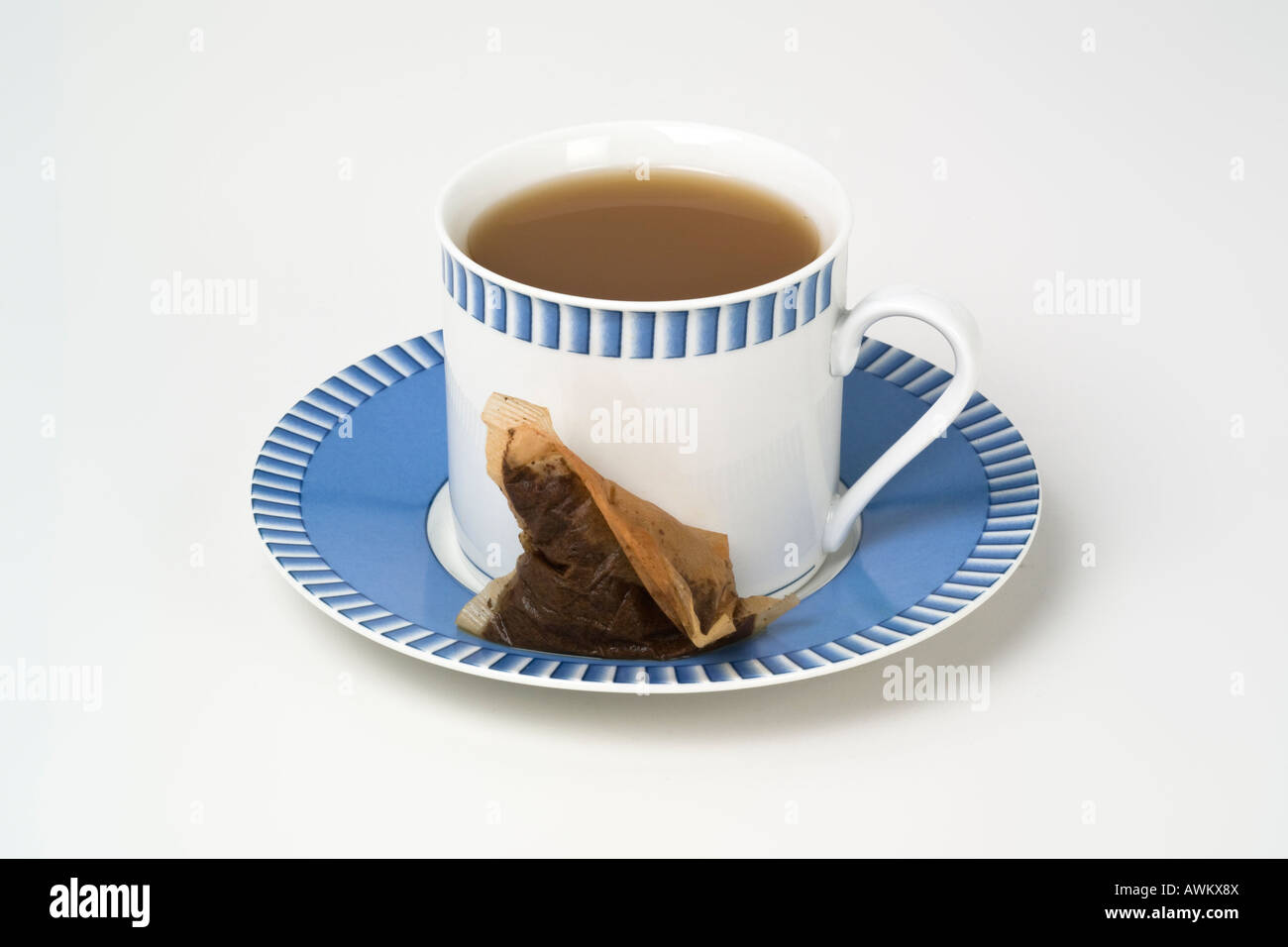 Used tea bag next to cup of tea Stock Photo - Alamy