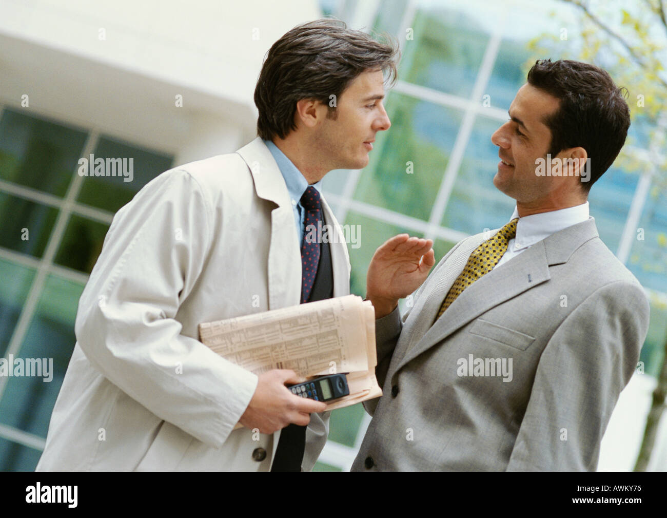 Two businessmen standing face to face, chatting, side view Stock Photo ...