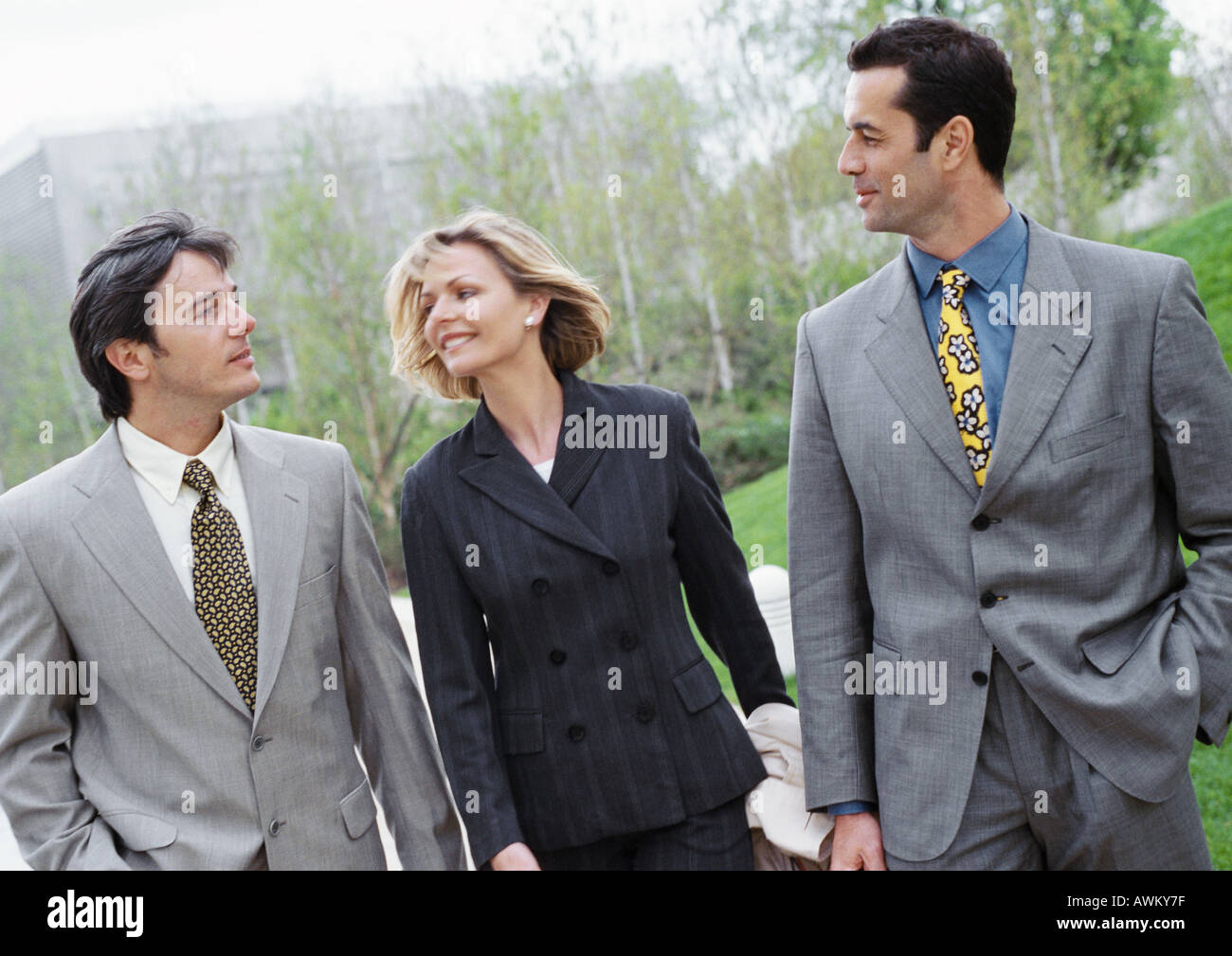 Three business people walking outside,smiling Stock Photo - Alamy