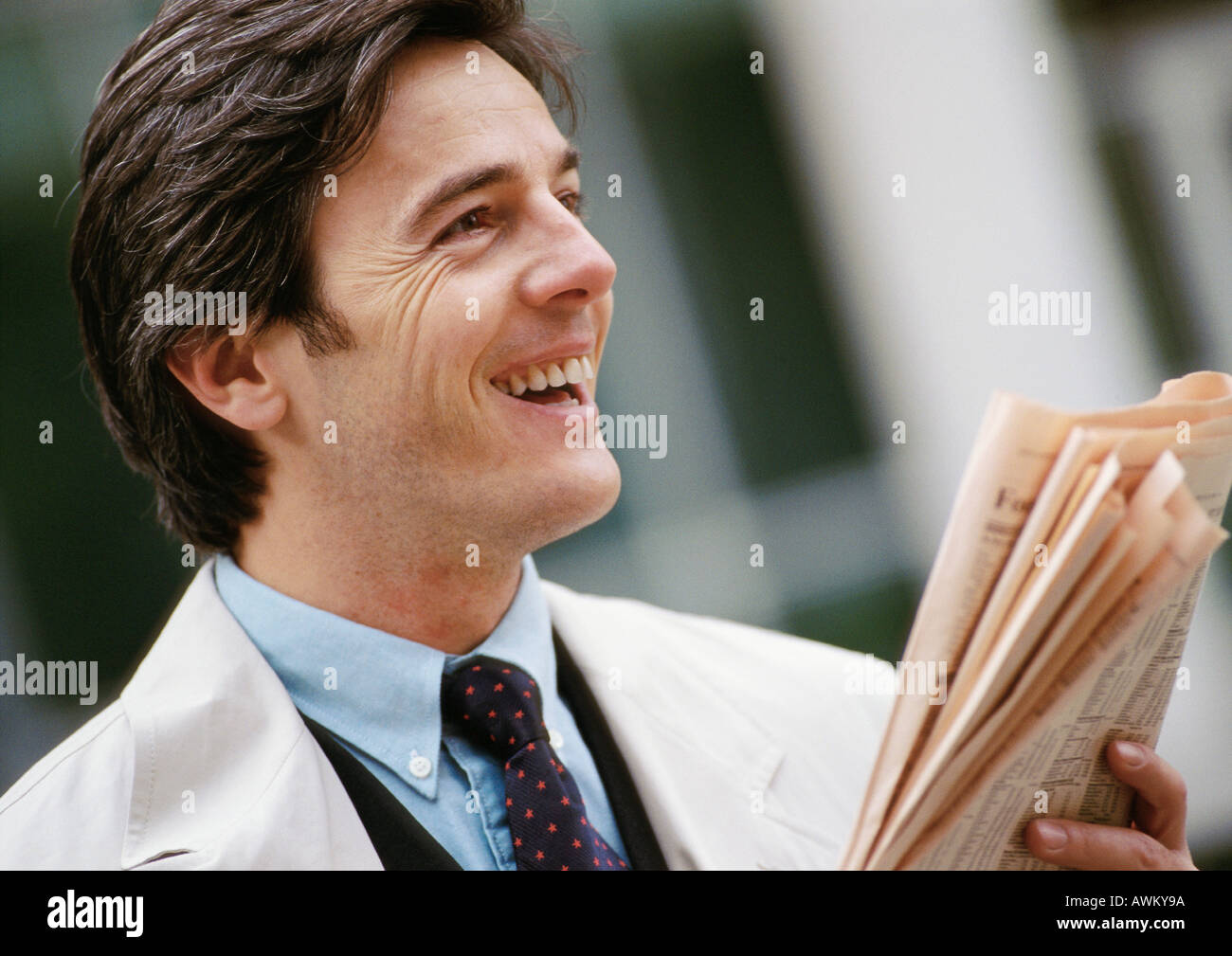 Businessman holding newspaper, smiling, portrait Stock Photo - Alamy