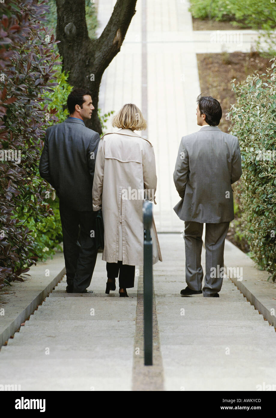 Three business people going down stairs, rear view Stock Photo - Alamy