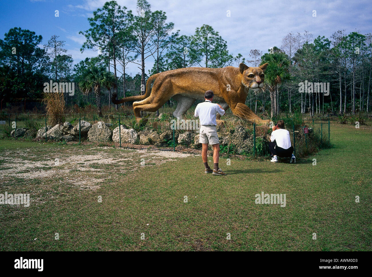 Tourists looking at sculpture of prehistoric animal, Everglades ...