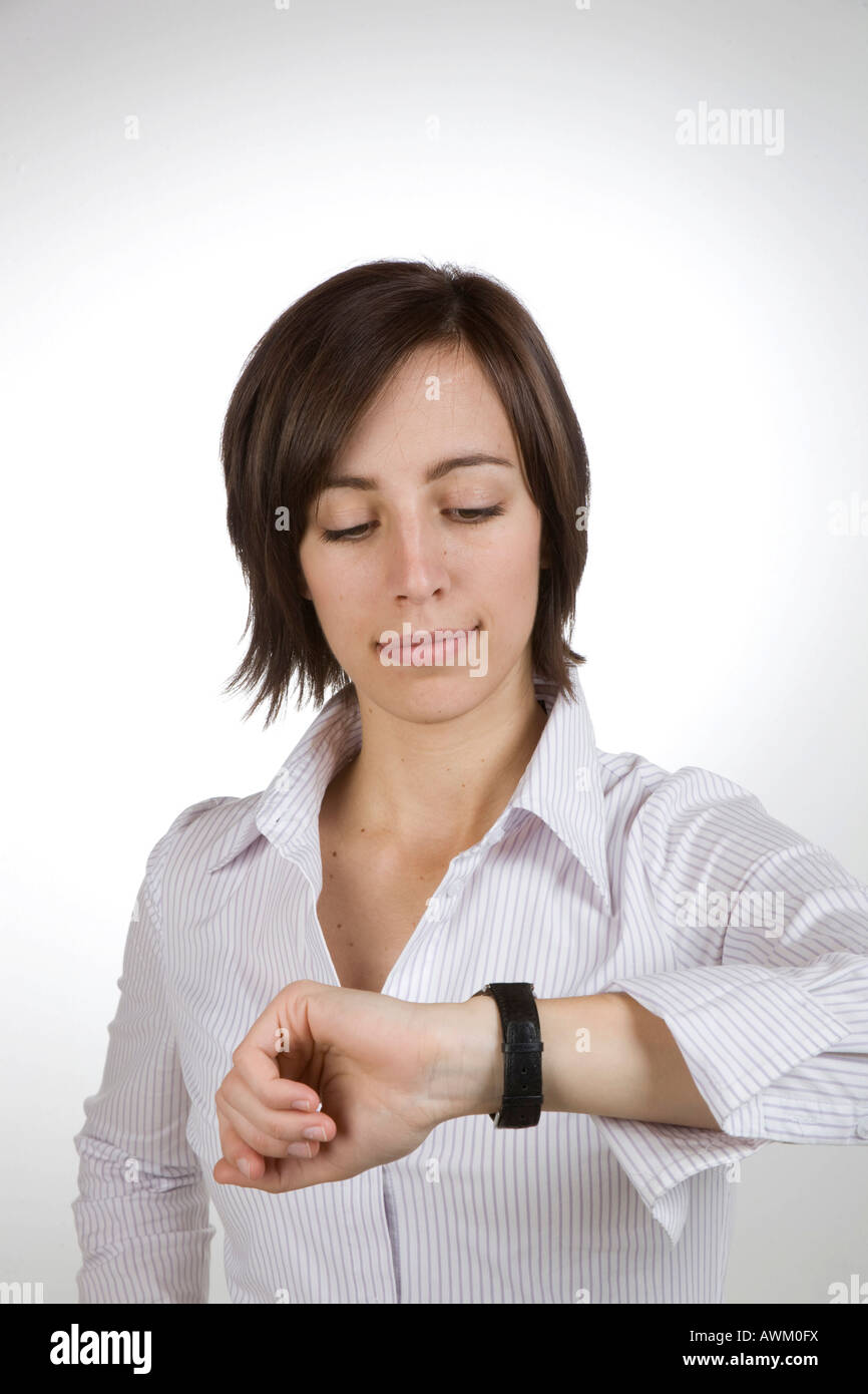 Young woman looking at her watch Stock Photo - Alamy
