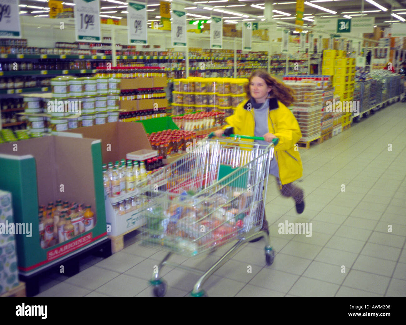 Woman running with a trolley in a supermarket Stock Photo - Alamy