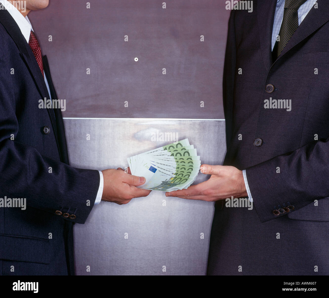Mid section view of two businessmen exchanging money Stock Photo - Alamy