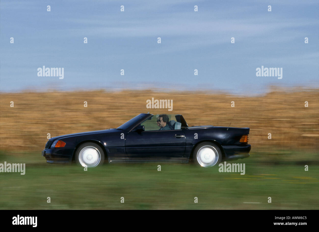 Side profile of man driving convertible car on road Stock Photo - Alamy