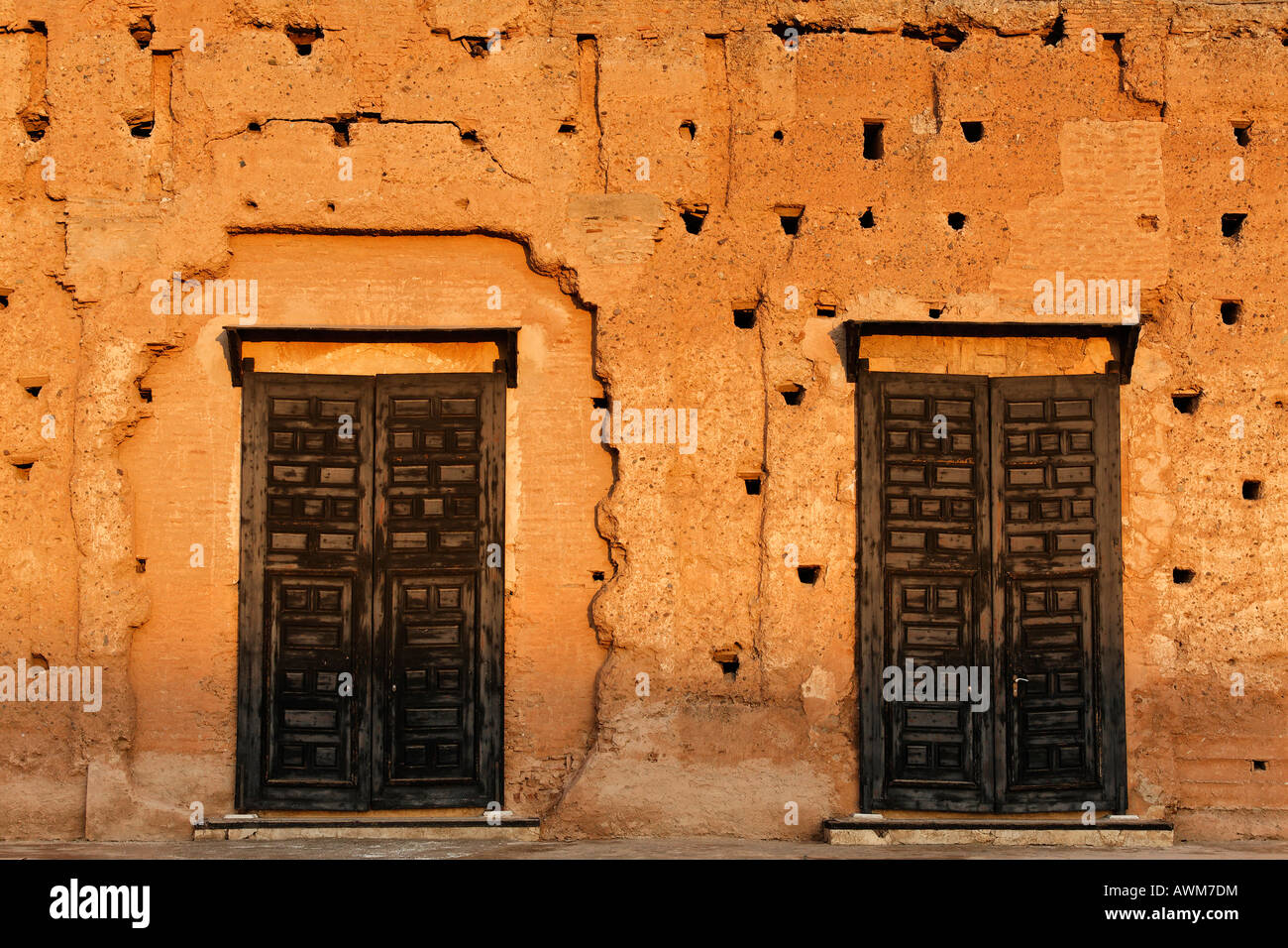 Old loam wall with two wooden doors, historic ruins of Palais EL Badi ...