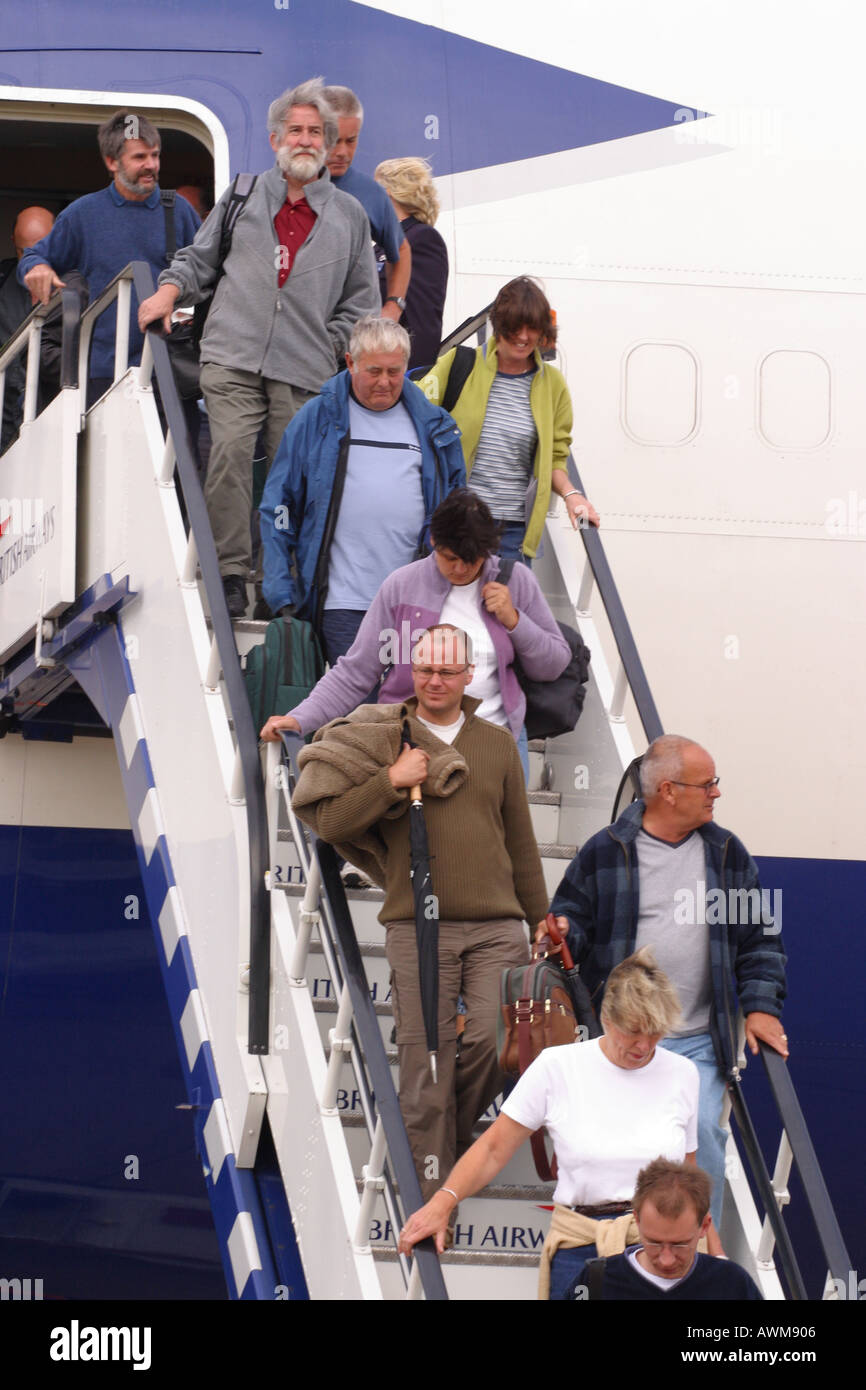 Airline holiday passengers disembarking from an airliner using airport ...