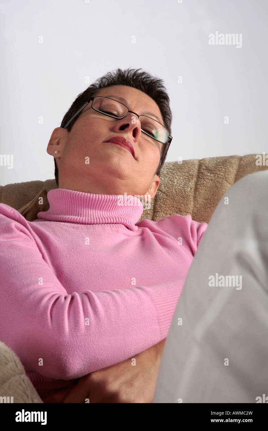 Woman napping comfortably on sofa Stock Photo - Alamy