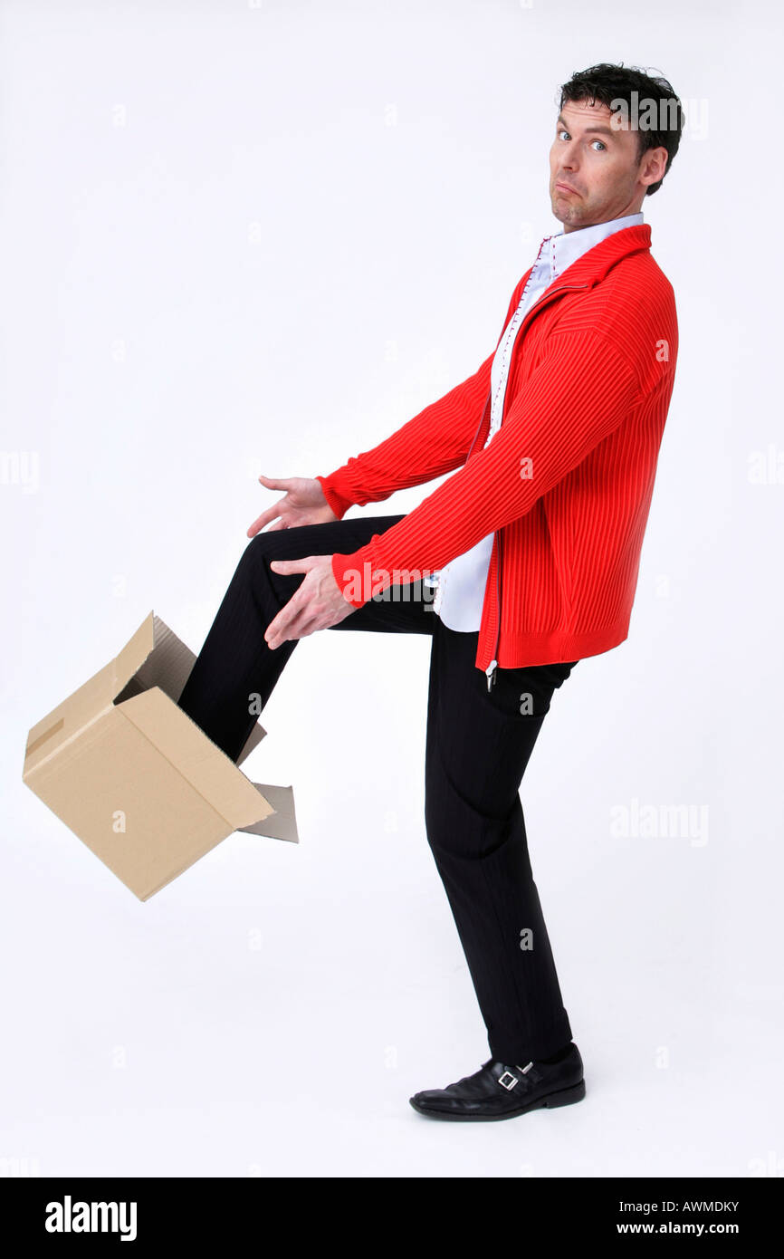 Man climbing into a small cardboard box Stock Photo - Alamy