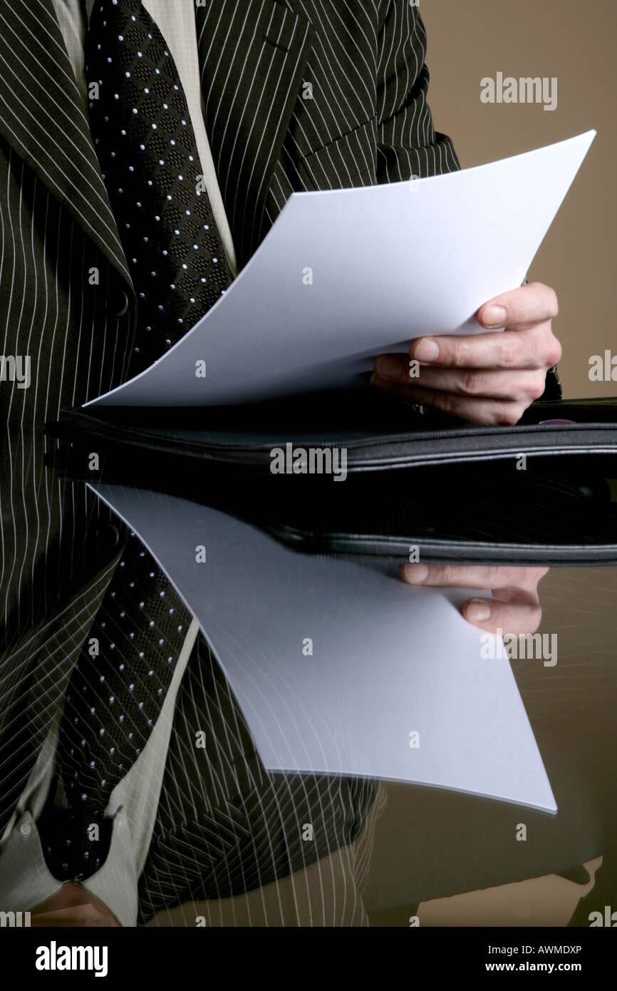 Businessman at his desk, close-up of his hand holding paper Stock Photo ...