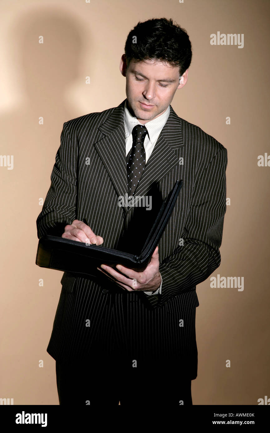 Businessman looking through file folder Stock Photo - Alamy