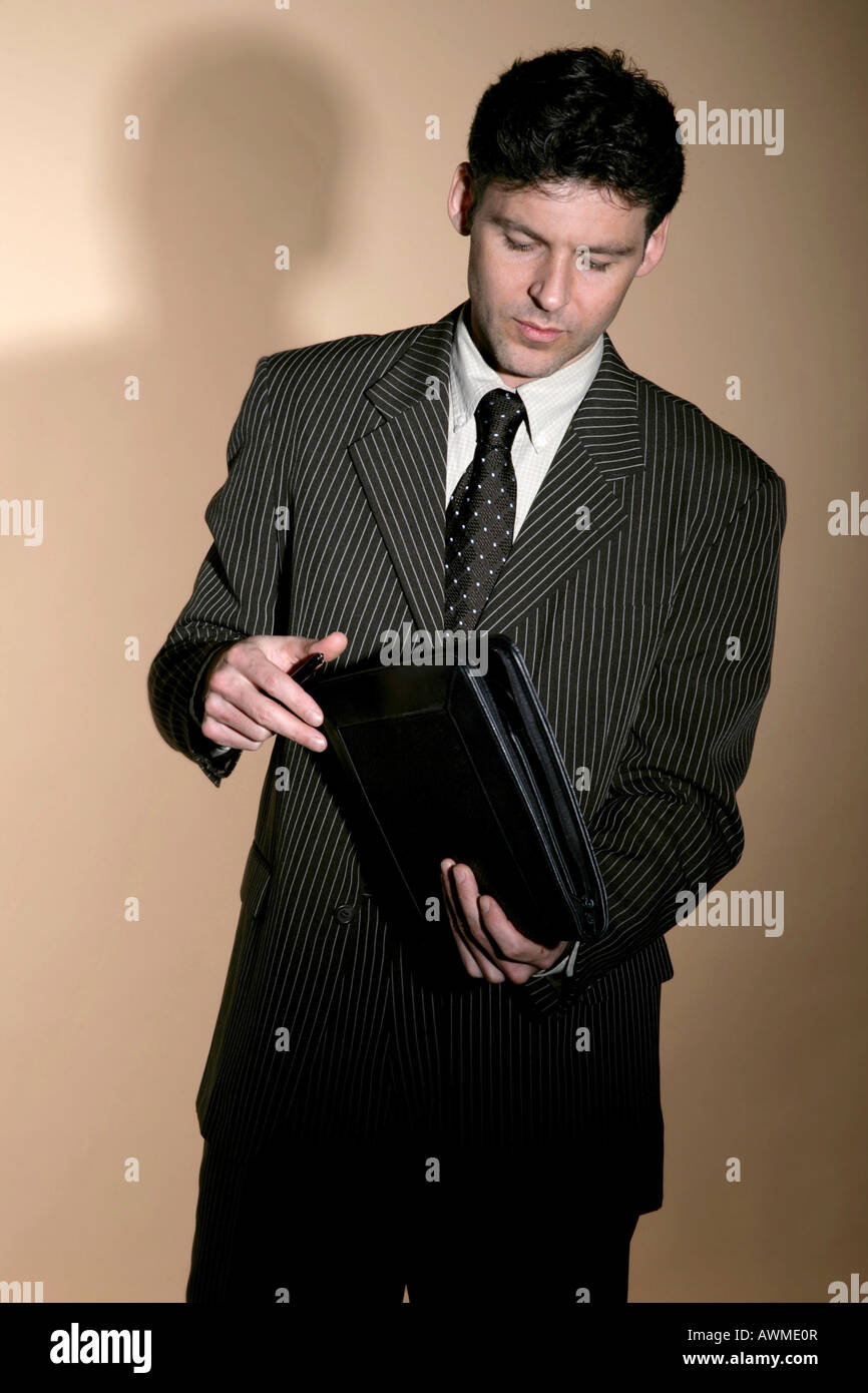 Businessman looking through file folder Stock Photo - Alamy