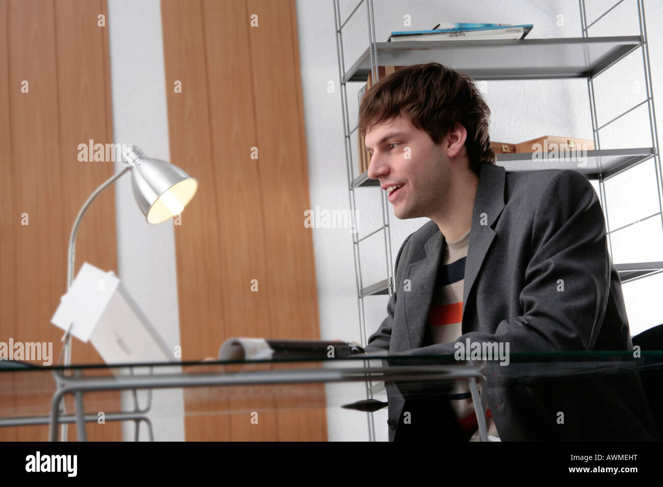 Young man working happily at his desk Stock Photo - Alamy
