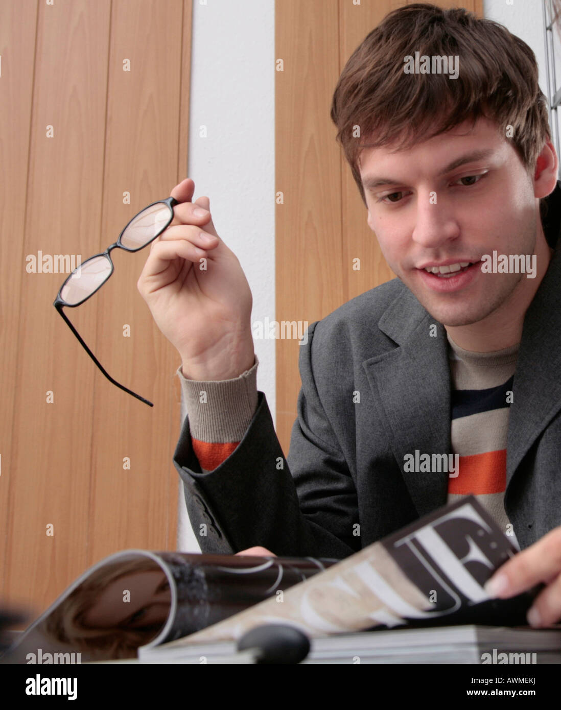 Young man reading a magazine at his desk Stock Photo - Alamy