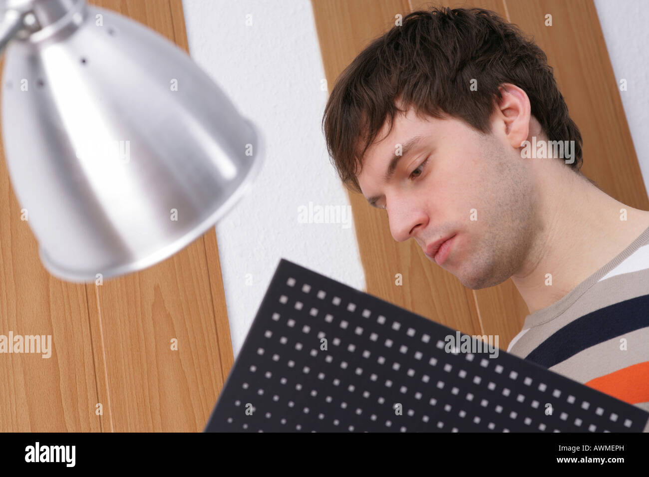 Young man looking though a file, focused Stock Photo - Alamy