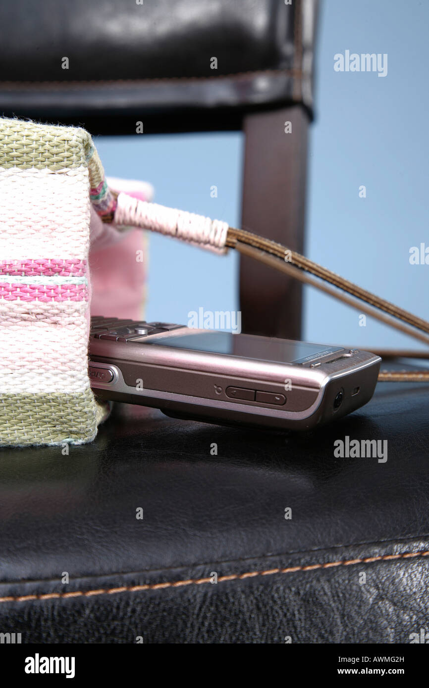Purse and mobile phone (cellphone) on a leather chair Stock Photo - Alamy