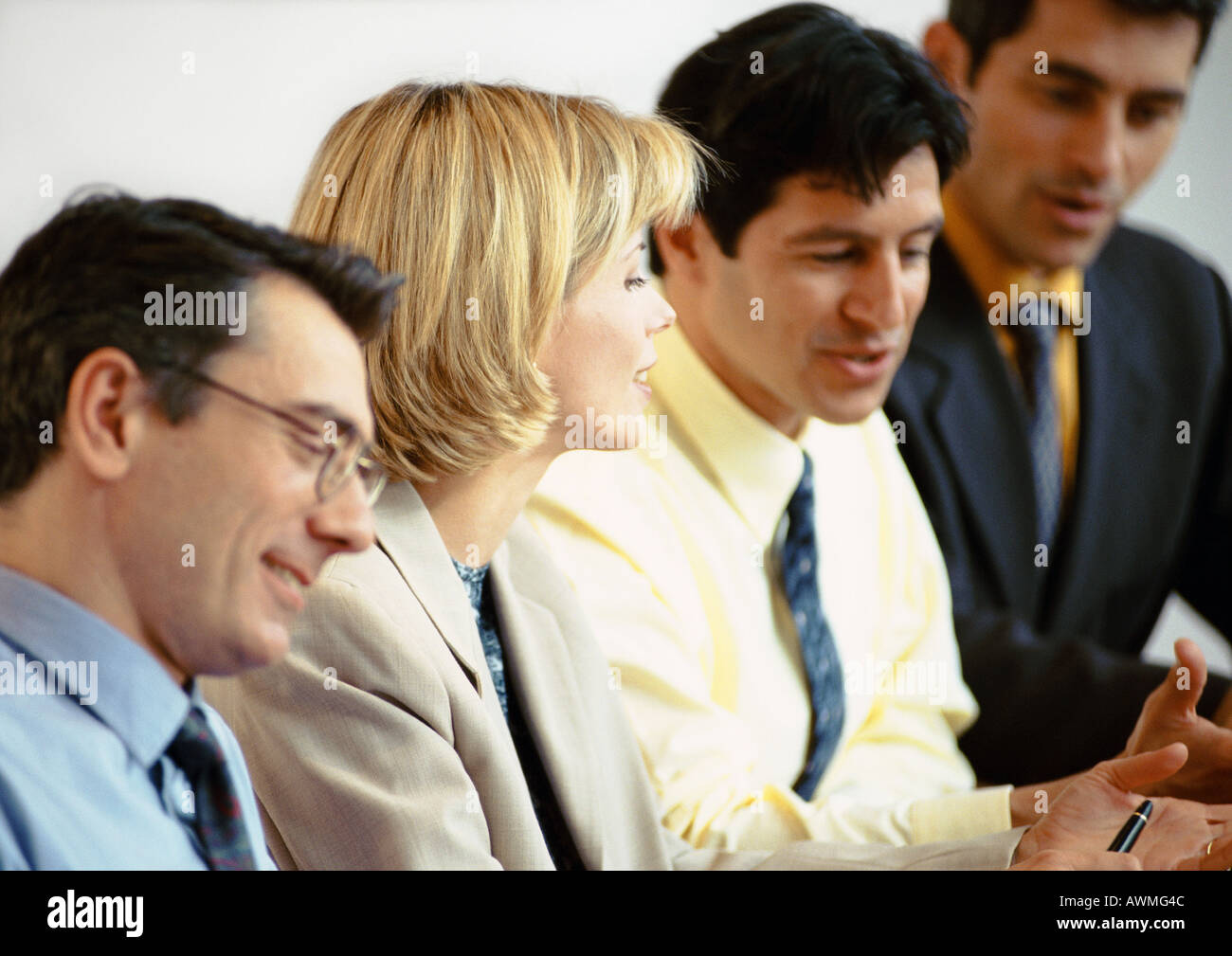 Four business people sitting side by side Stock Photo - Alamy