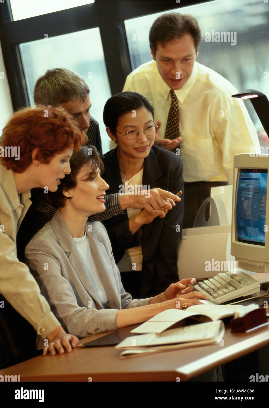 Five business people looking at computer screen Stock Photo - Alamy
