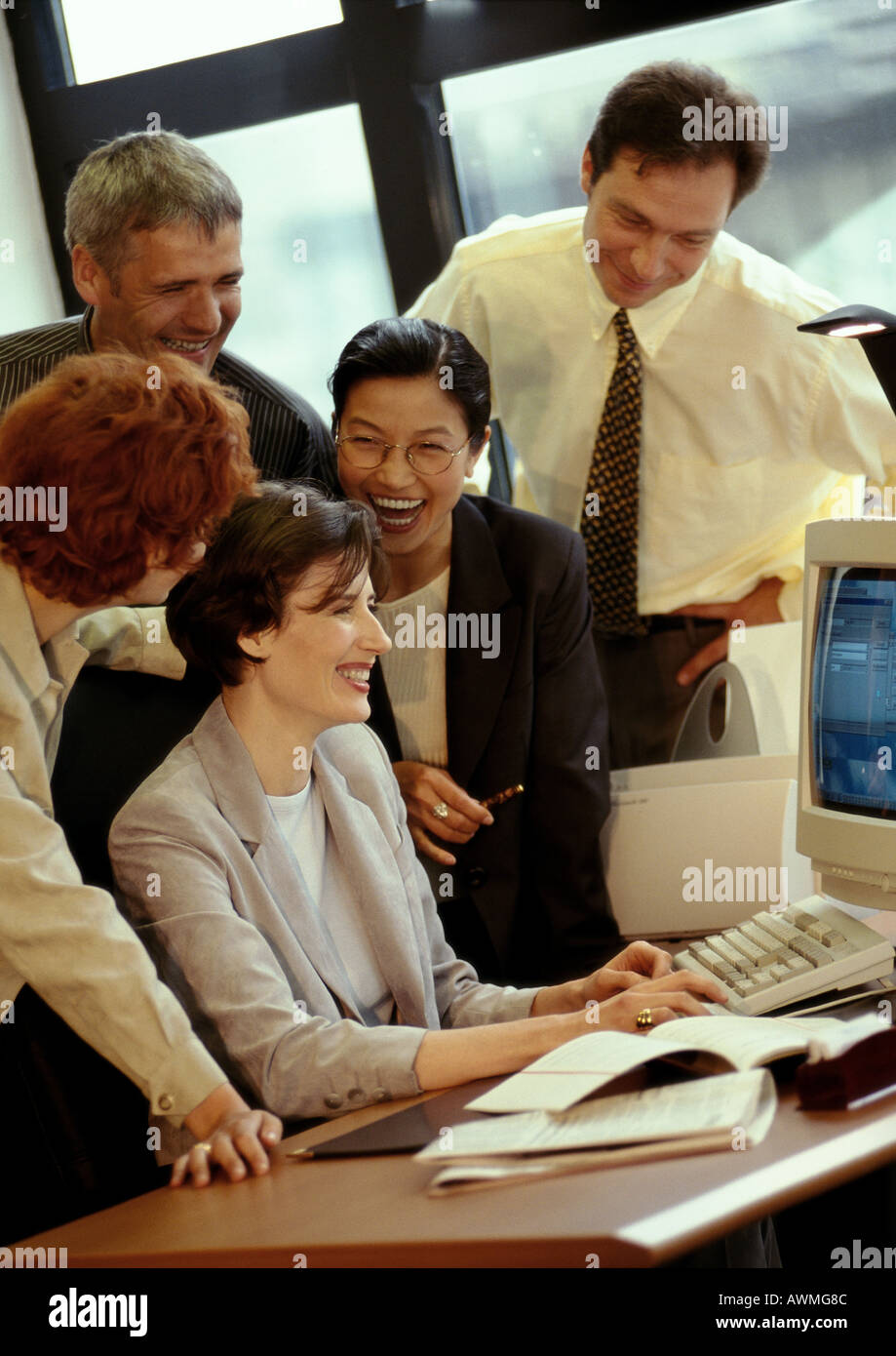 Office workers gathered around computer hi-res stock photography and ...