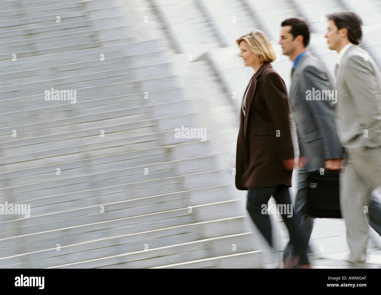 Three business people walking side by side, side view, blurred Stock ...