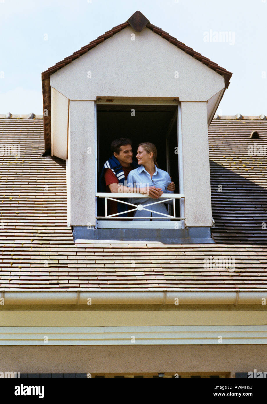 Couple standing at dormer window Stock Photo - Alamy