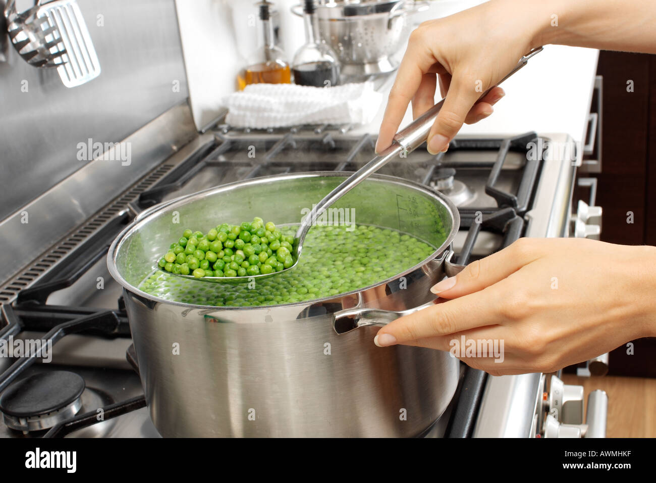 WOMAN IN KITCHEN COOKING PEAS Stock Photo - Alamy