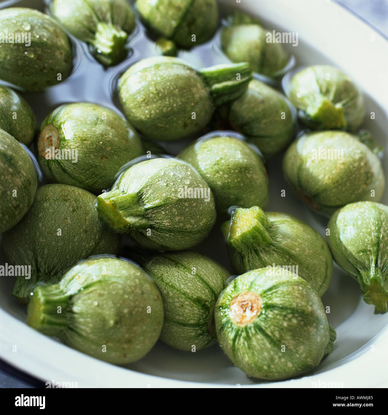Globe zucchini being rinsed Stock Photo - Alamy