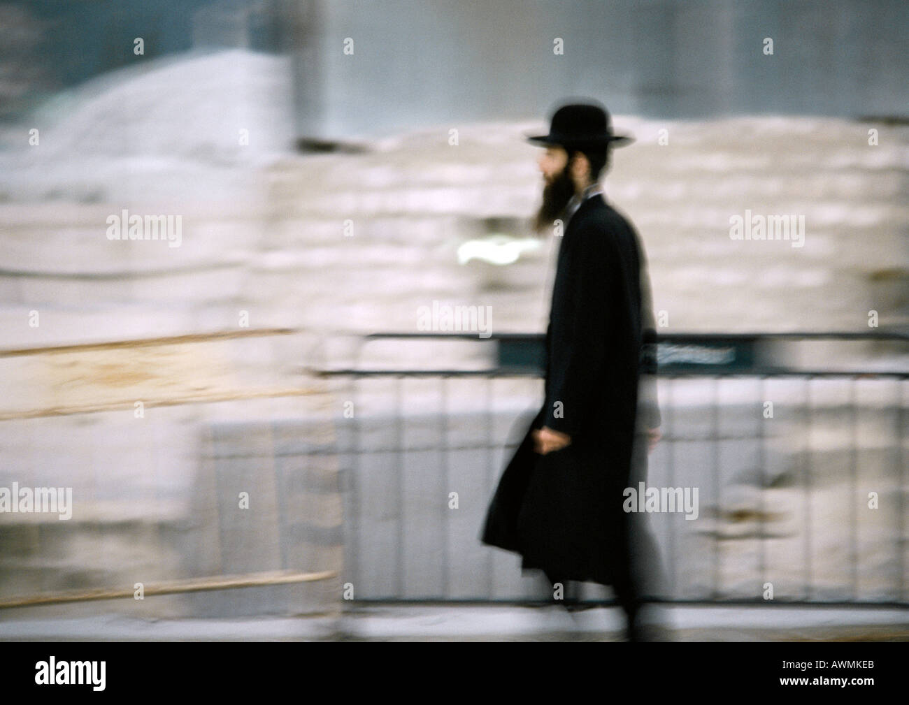 Israel, Jerusalem, Orthodox Jew walking by barrier, side view, blurred ...