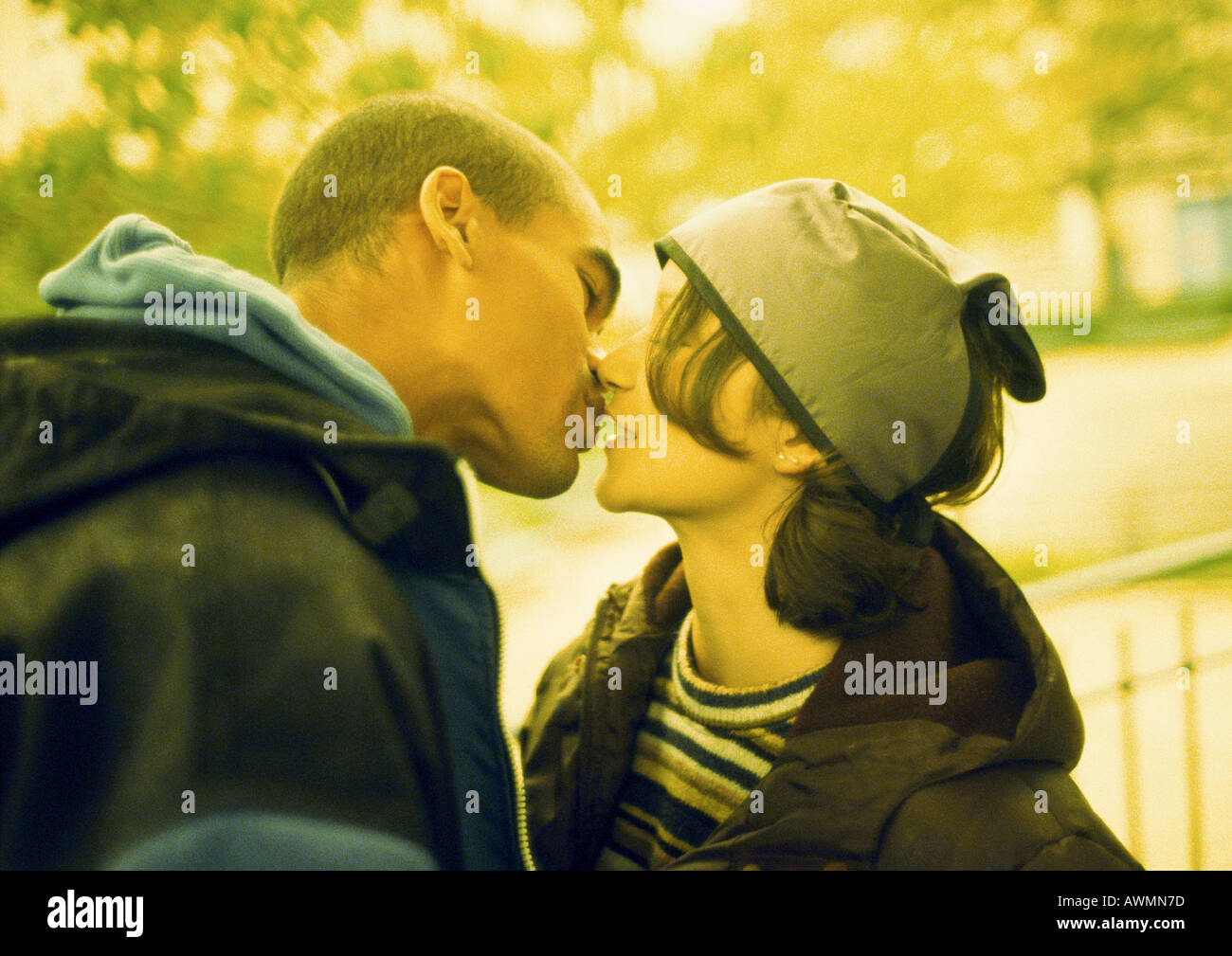 Young couple kissing, side view Stock Photo - Alamy
