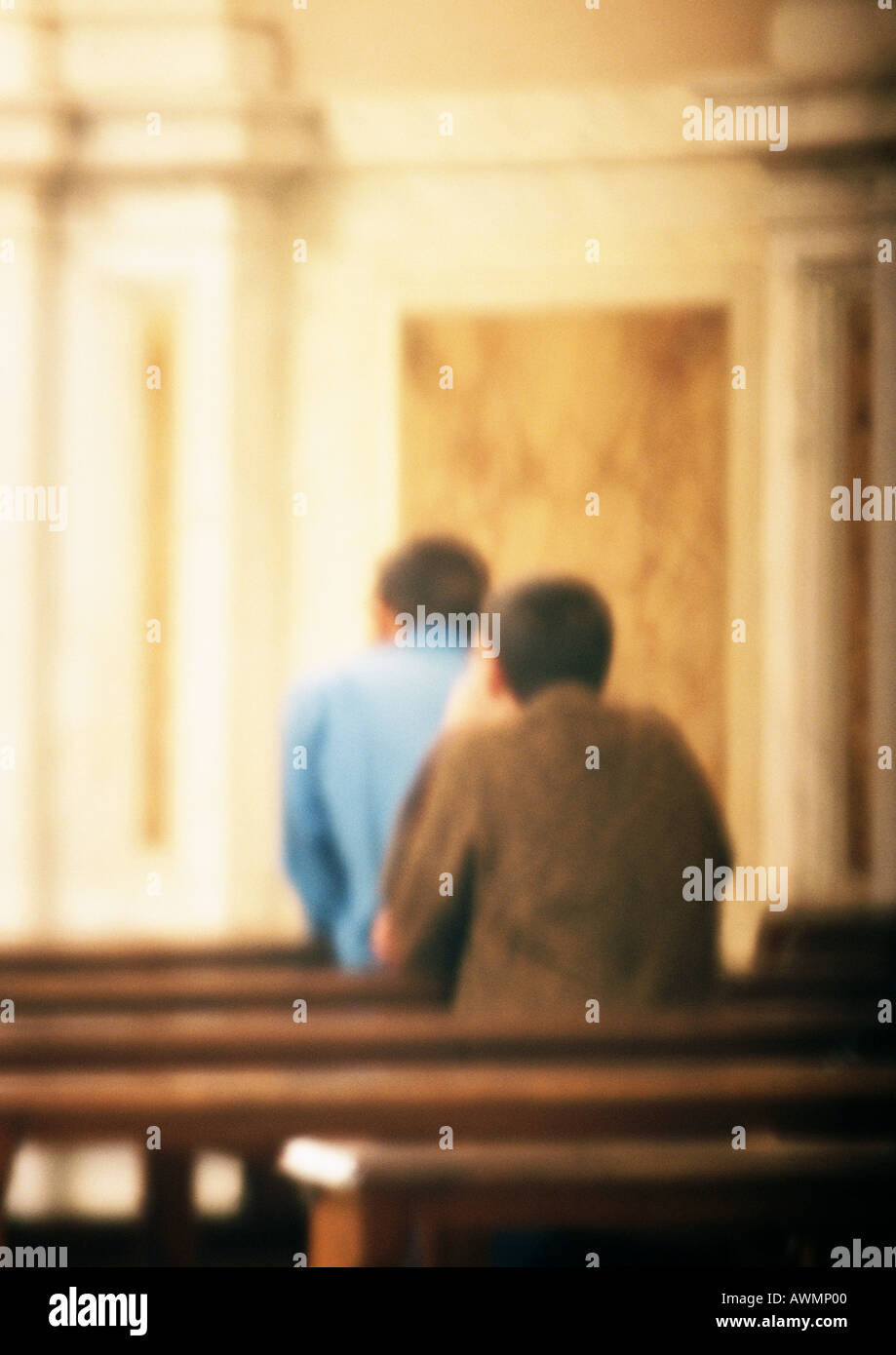 Two people praying in church, rear view, blurred Stock Photo - Alamy