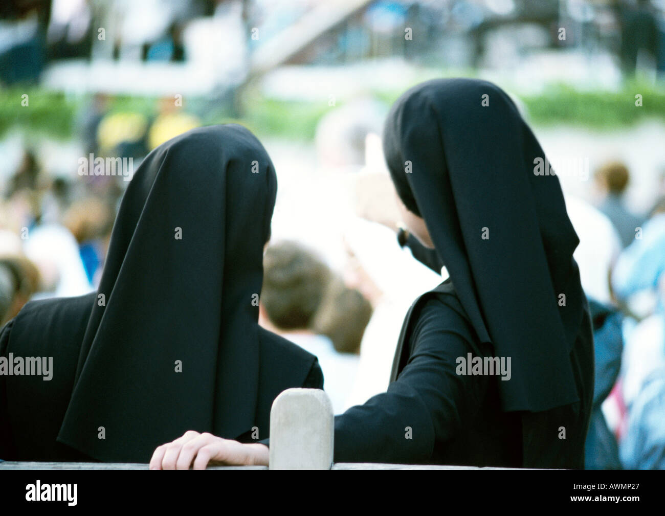 Two nuns standing side by side, overlooking crowd, rear view Stock ...