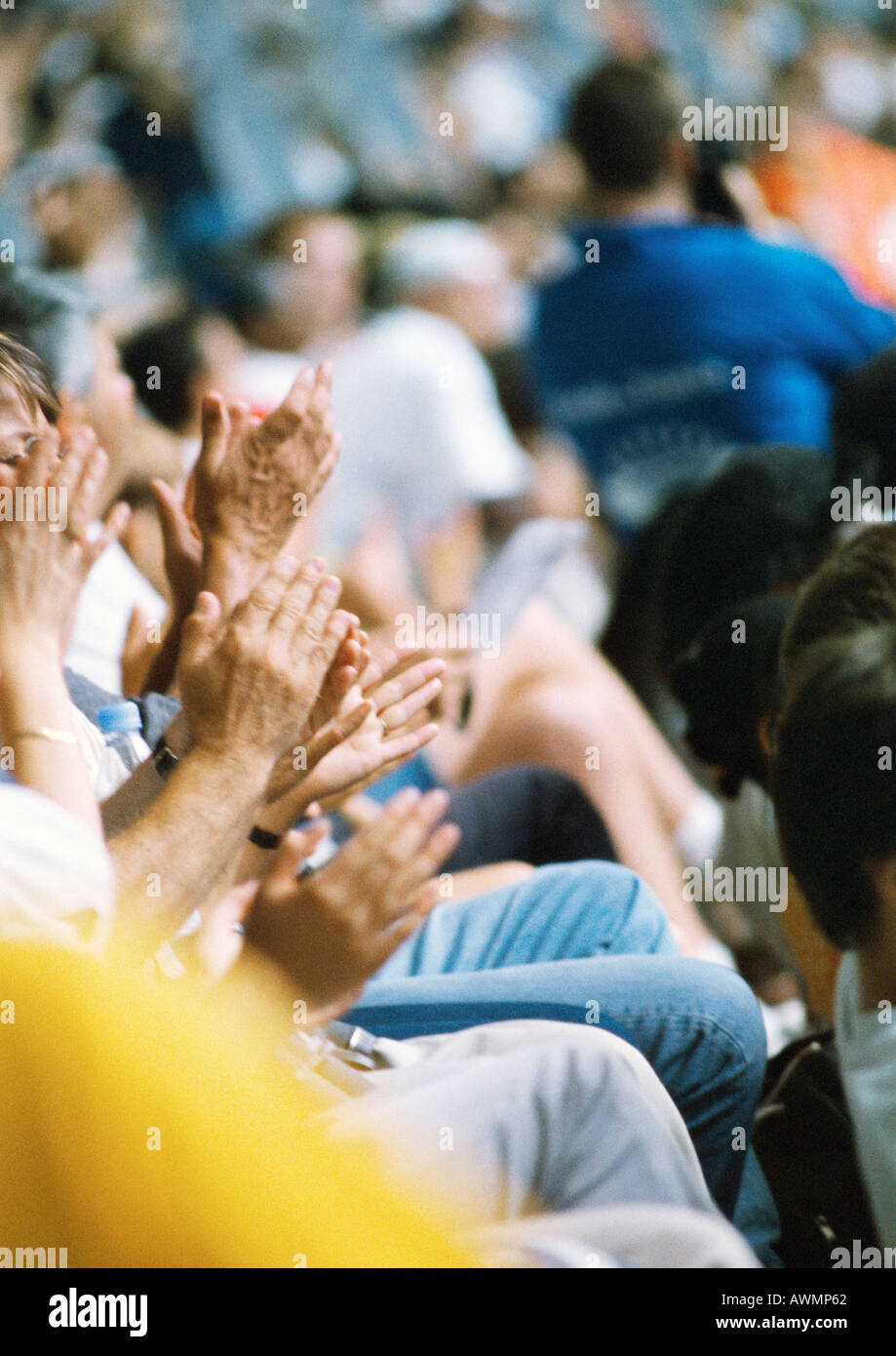People sitting side by side clapping, side view Stock Photo - Alamy