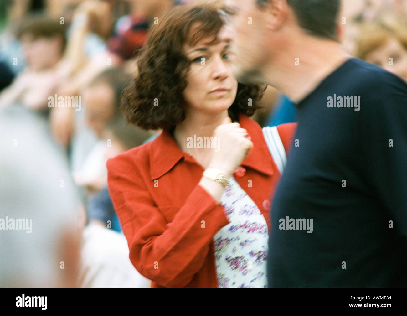 Woman in crowd looking into camera, outside Stock Photo - Alamy