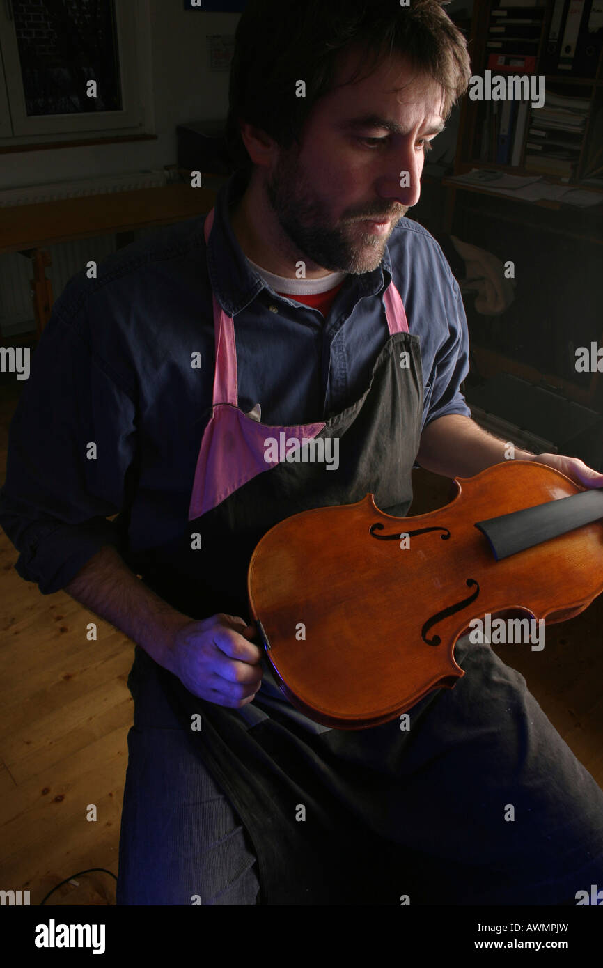 Violin-maker (luthier) stringing a violin Stock Photo - Alamy