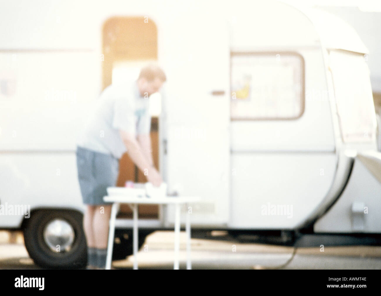 Man standing in front of camper, blurred Stock Photo - Alamy