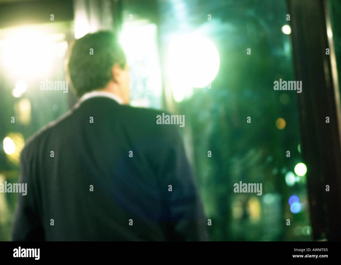 Business man, rear view, with glare of lights, blurred Stock Photo - Alamy