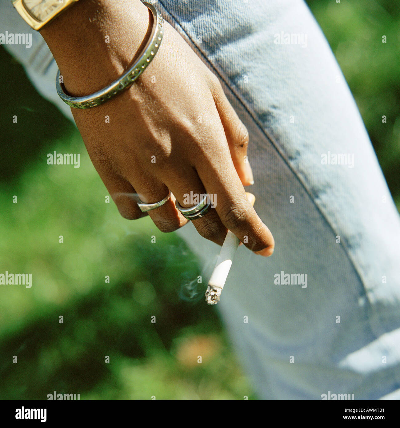 Young woman's hand holding lit cigarette, close-up Stock Photo - Alamy